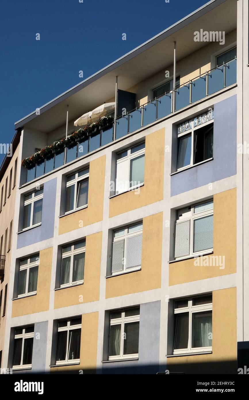 Exterior of a modern urban apartment building with open windows on a ...