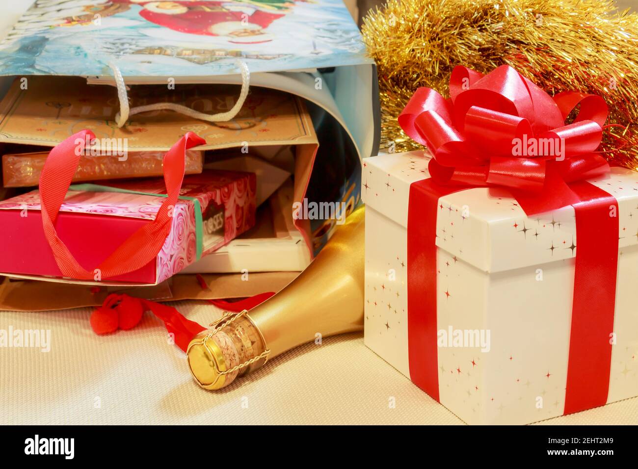 Christmas gift - a box with red ribbon, champagne and bag of sweets and ...
