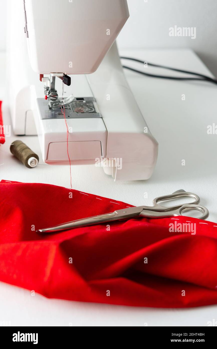 Modern sewing machine with red and gray fabric, thread and scissors ...