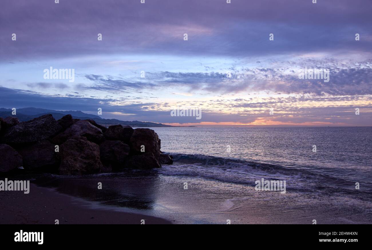 Picturesque scene of the purple toned sunset above sea waters seen ...