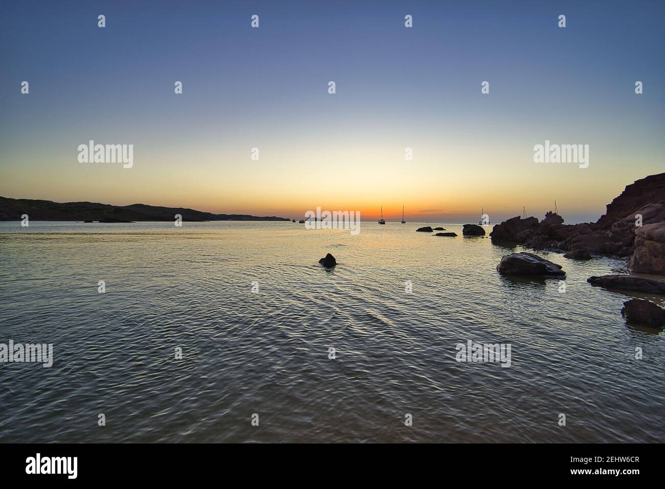 Beautiful orange toned sunset above the boundless sea with silhouettes ...