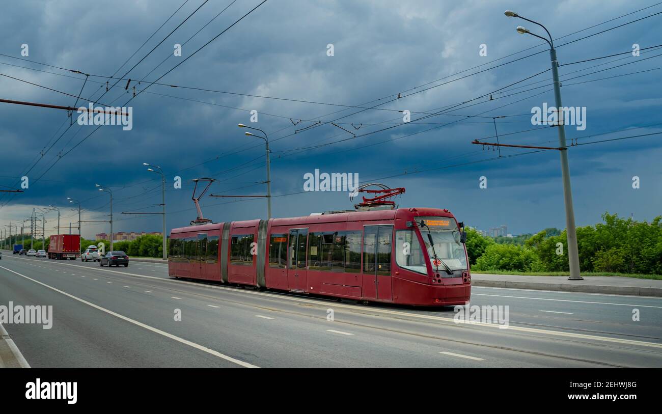 Red modern tram on the street in Kazan, Russia. Kazan's tram networks ...