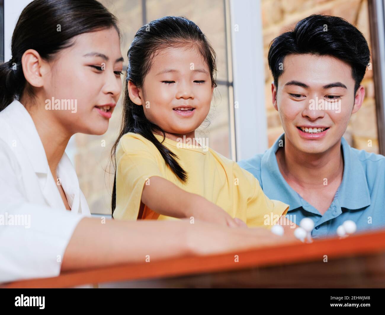 Happy family of three doing molecular structure model Stock Photo - Alamy
