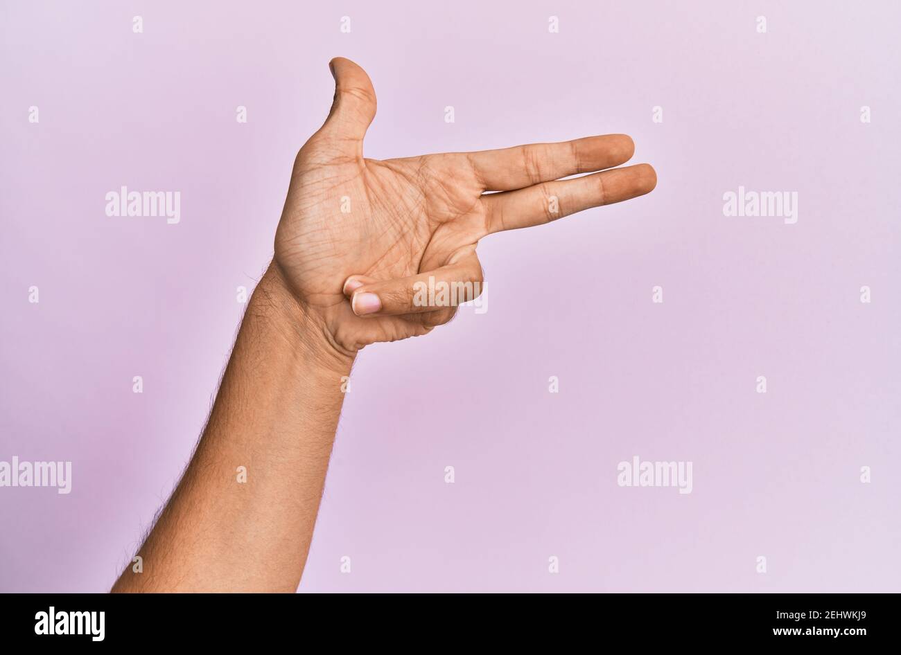 Arm and hand of caucasian young man over pink isolated background ...