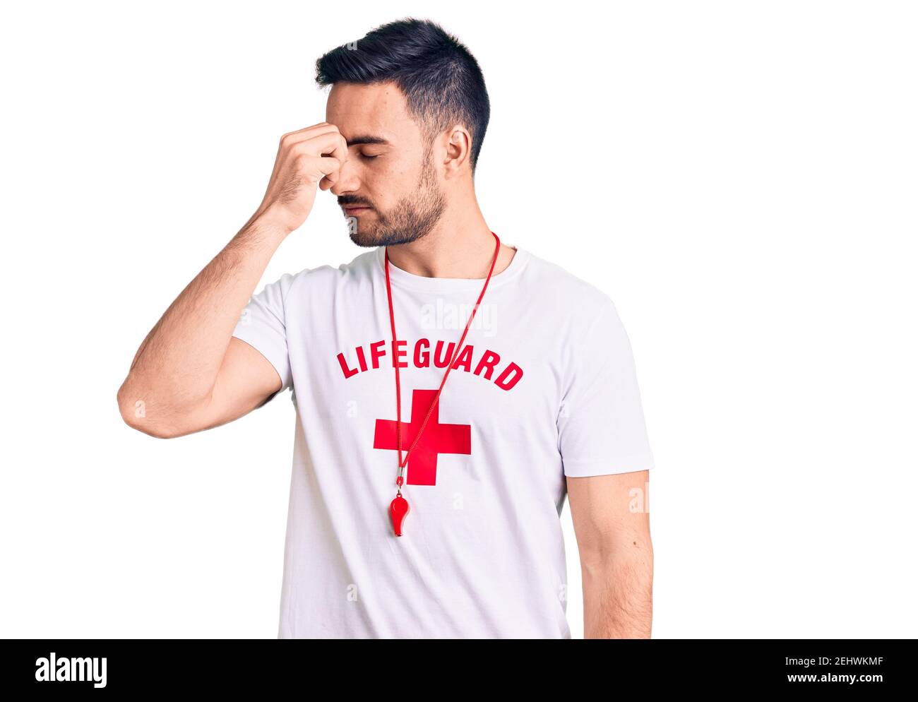 Young handsome man wearing lifeguard uniform tired rubbing nose and ...