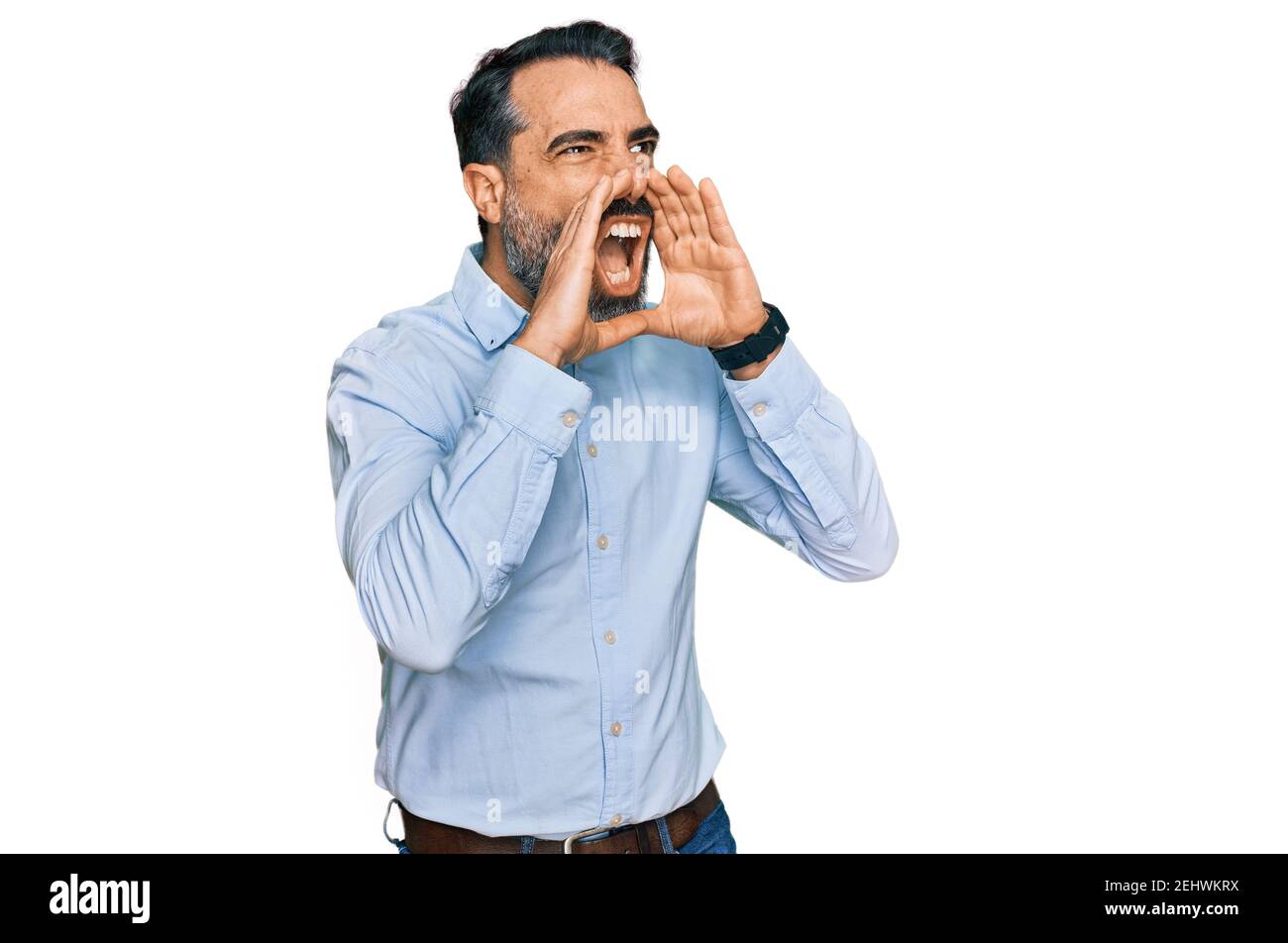 Middle aged man with beard wearing business shirt shouting angry out ...