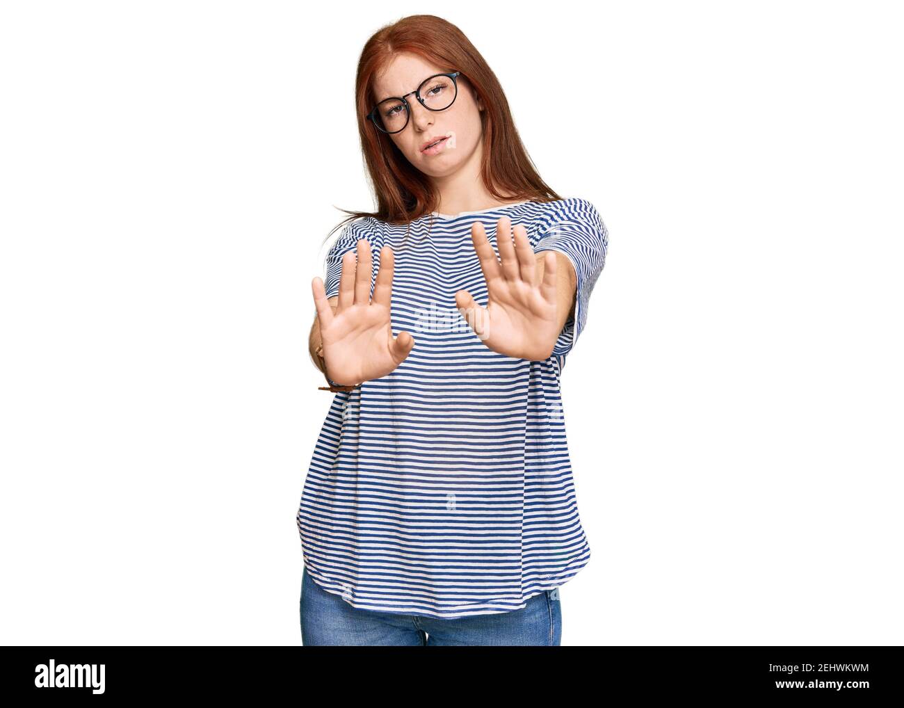 Young read head woman wearing casual clothes and glasses moving away ...