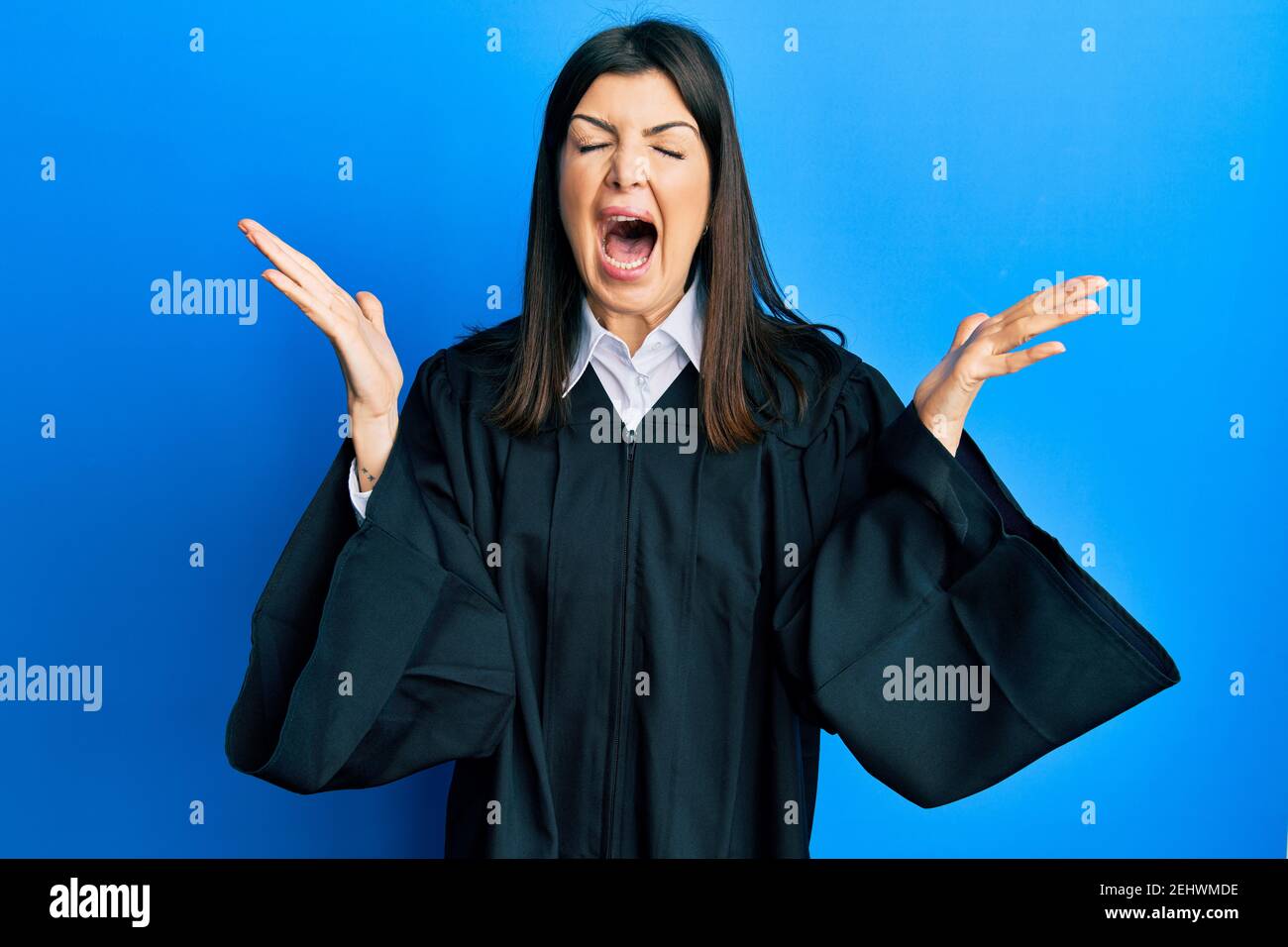 Young hispanic woman wearing judge uniform celebrating mad and crazy ...