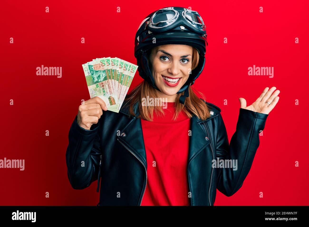 Hispanic young woman wearing motorcycle helmet holding hong kong ...
