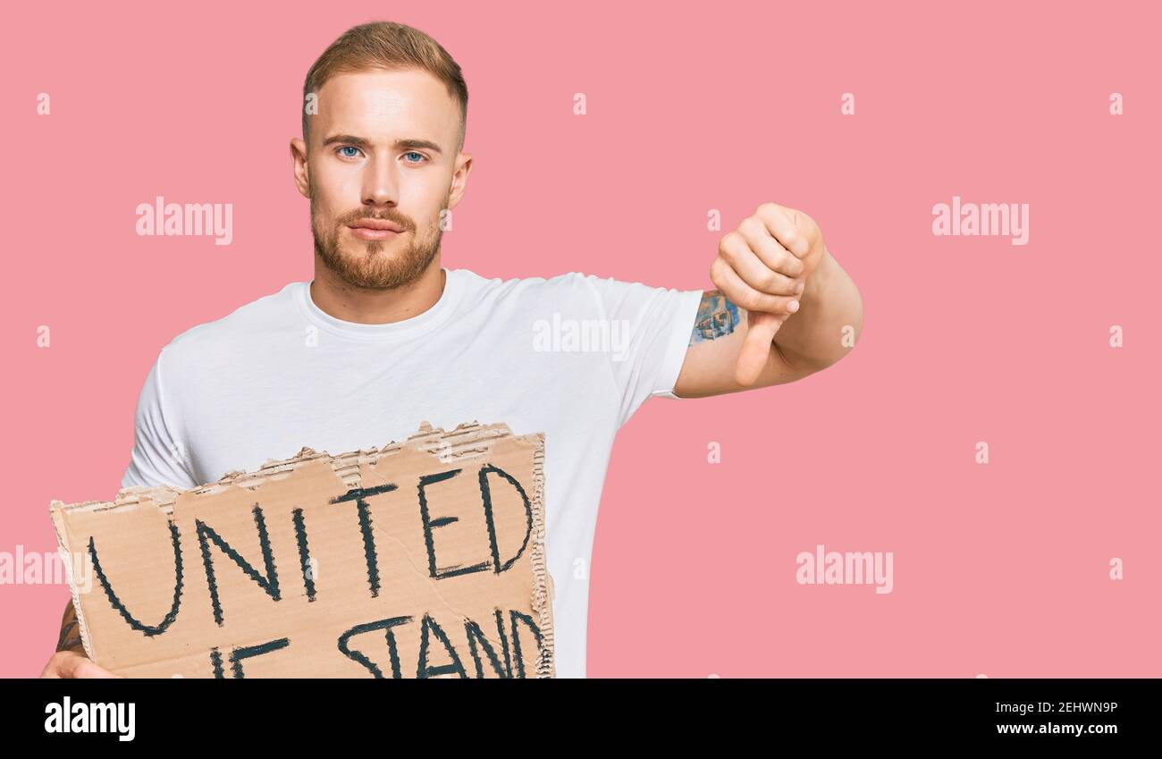 Young irish man holding united we stand banner with angry face ...