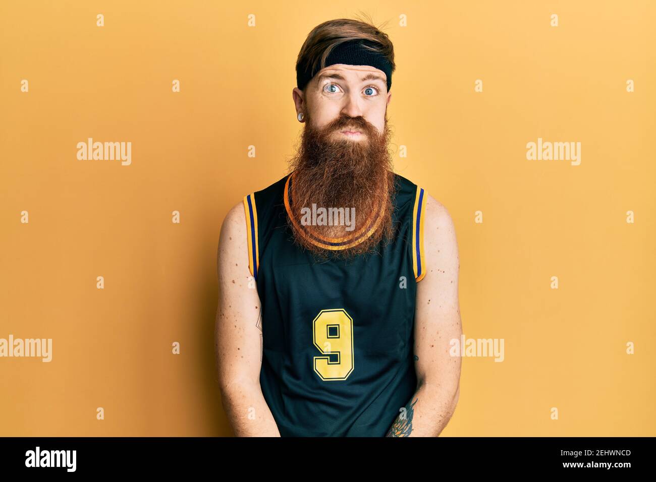 Redhead Man With Long Beard Wearing Basketball Uniform Puffing Cheeks