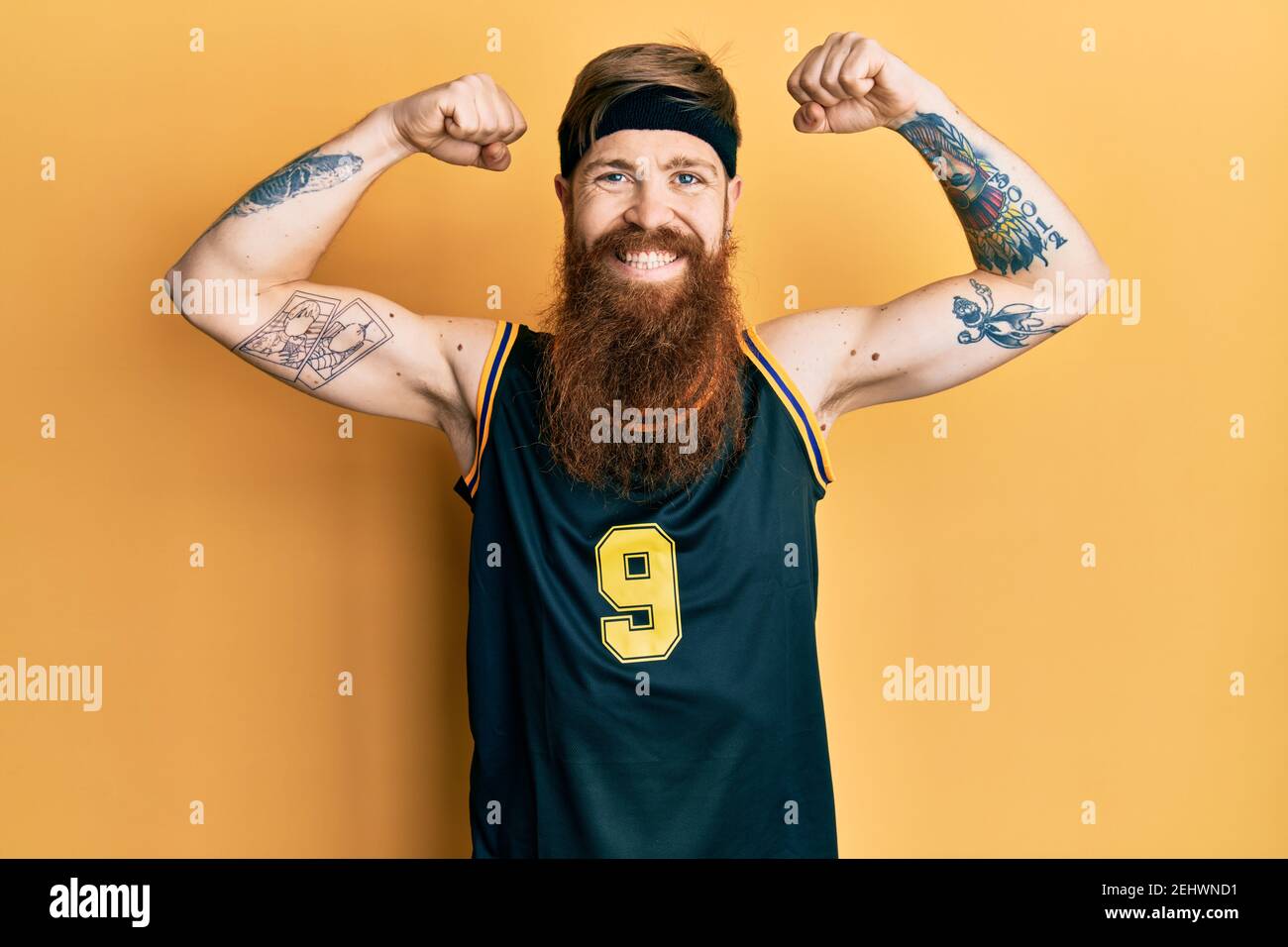 Redhead Man With Long Beard Wearing Basketball Uniform Showing Muscles