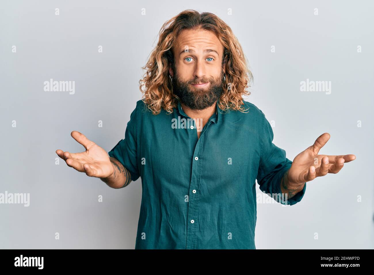Handsome man with beard and long hair wearing casual clothes clueless ...