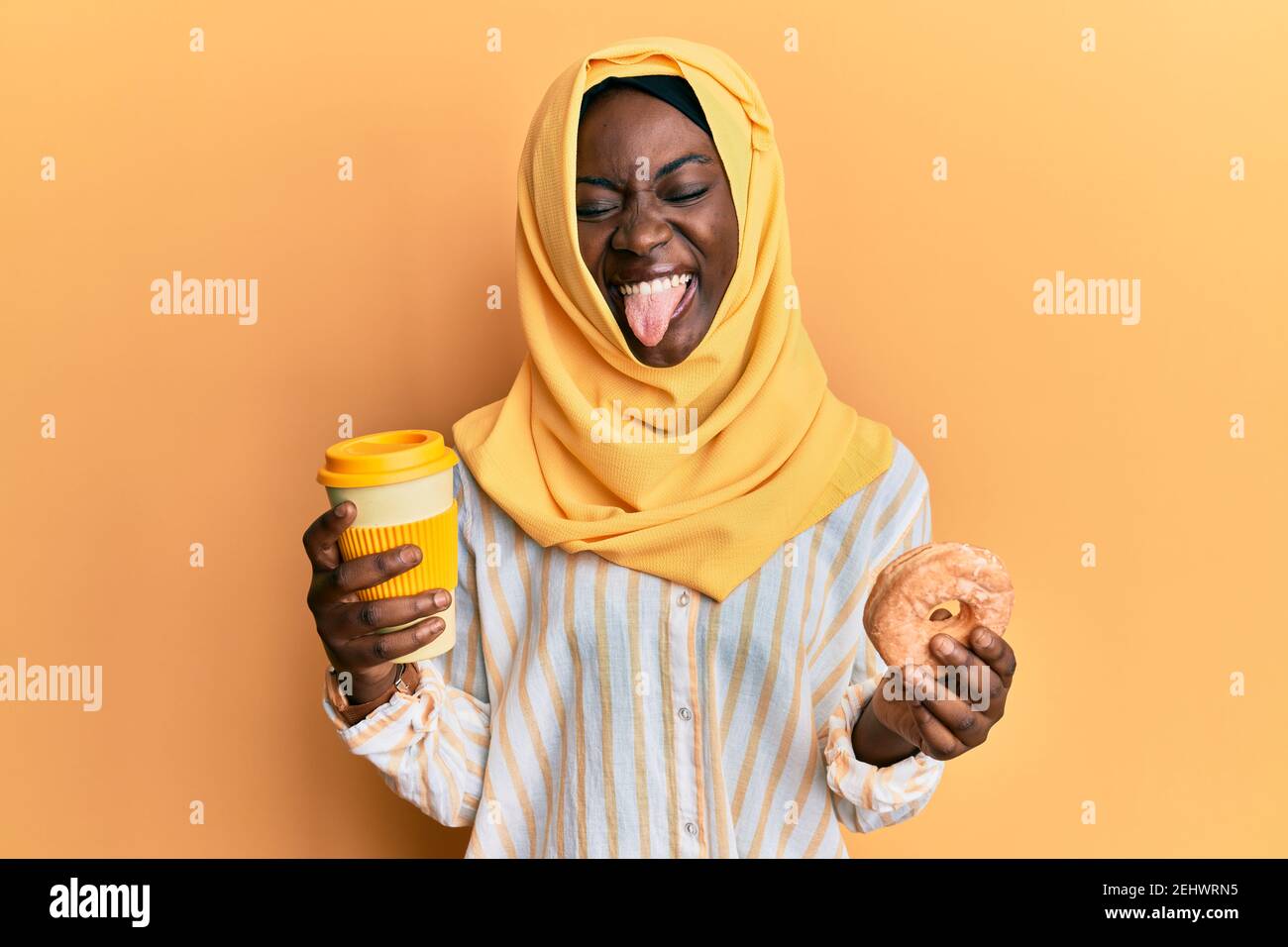 Beautiful african young woman wearing islamic hijab drinking a coffee ...