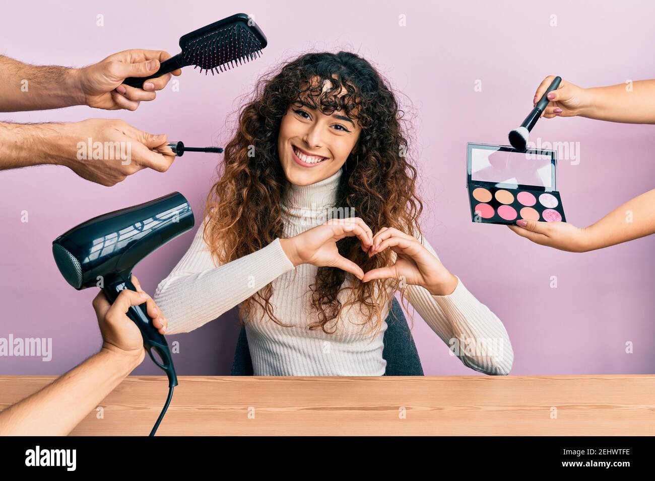 Young hispanic girl sitting on the table with hands holding cosmetic ...