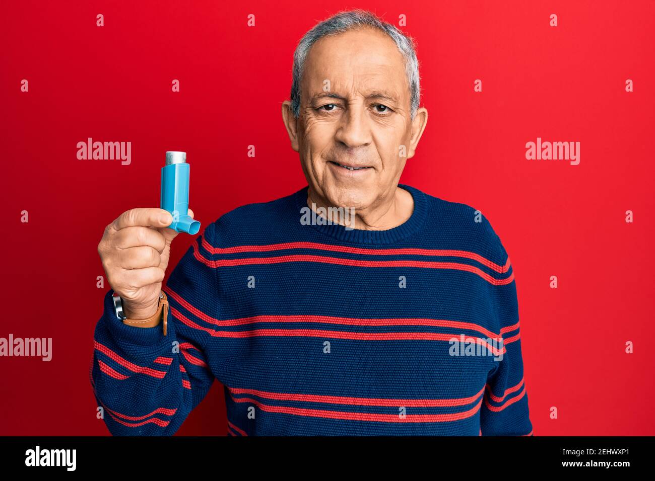 Senior hispanic man holding medical asthma inhaler looking positive and ...