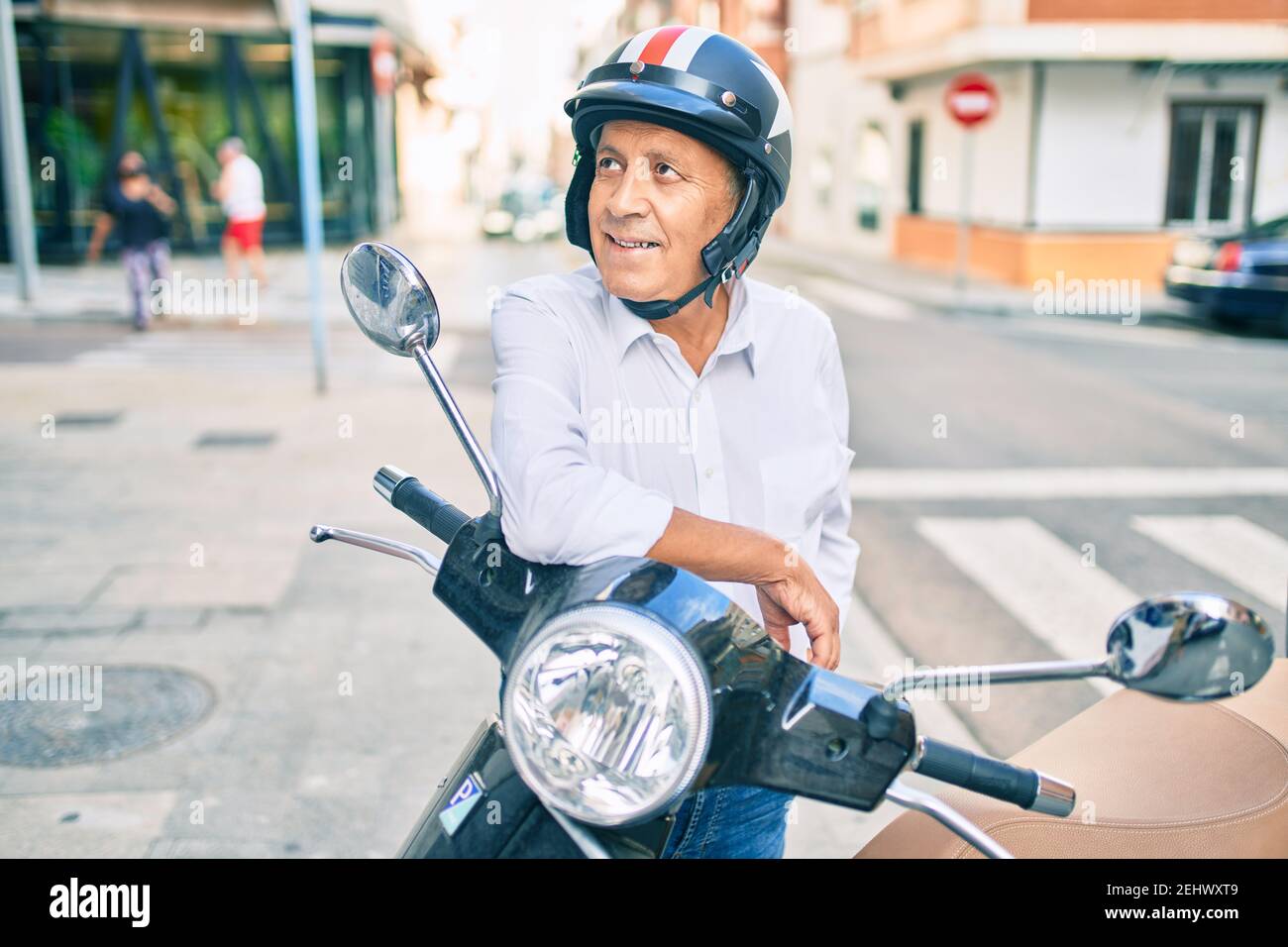 Senior motorcyclist man smiling happy wearing moto helmet at the city ...