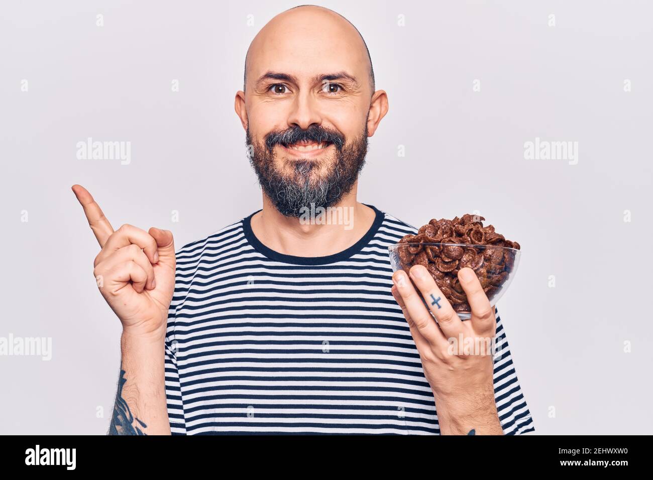 Young handsome man holding chocolate cereals smiling happy pointing ...