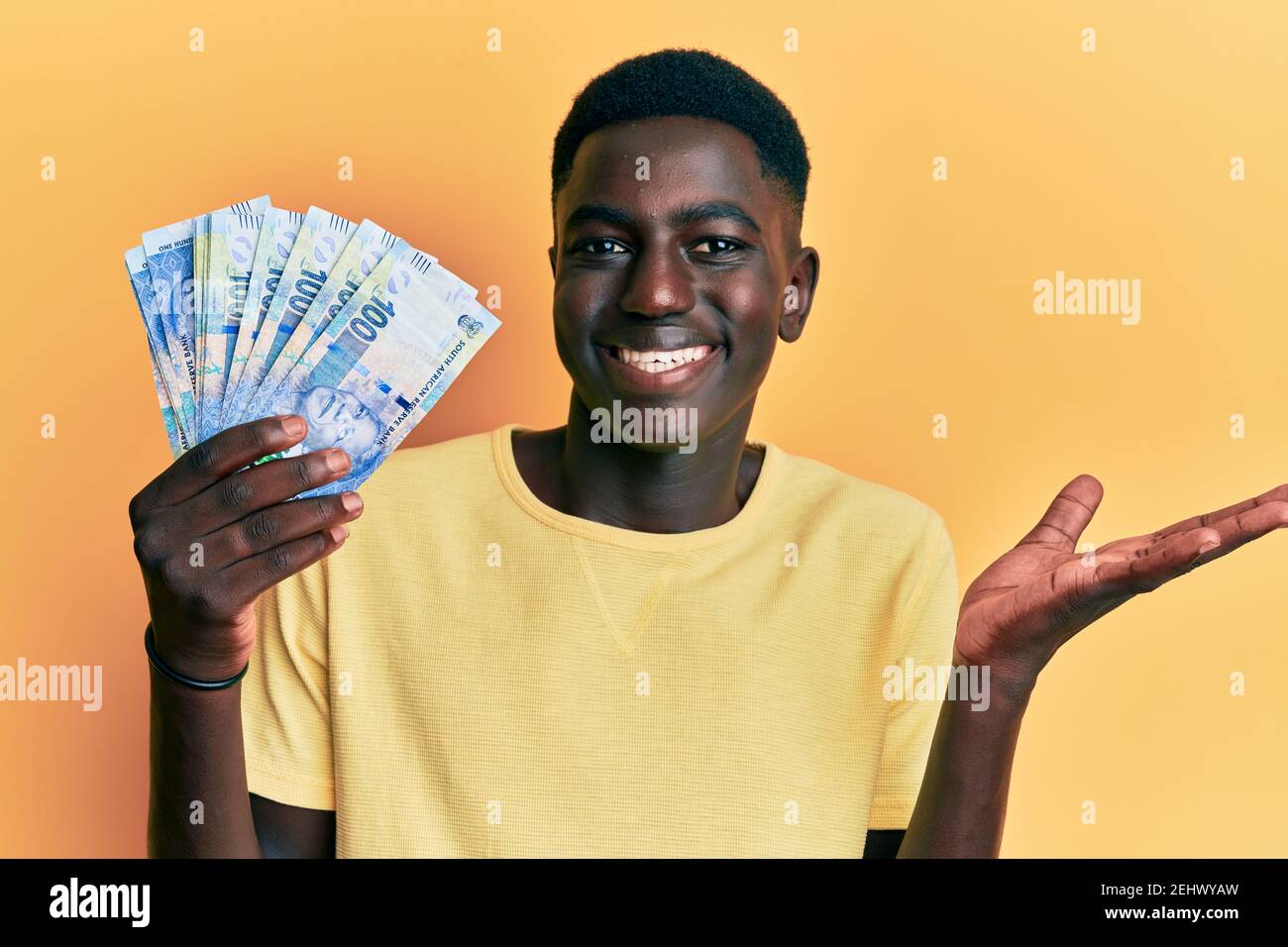 Young african american man holding south african rand banknotes ...