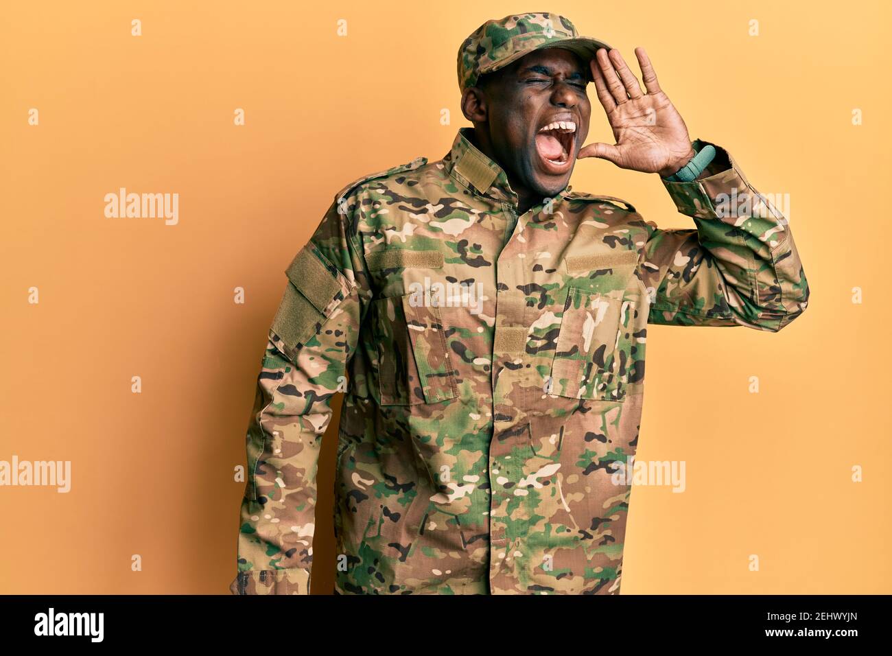 Young african american man wearing army uniform shouting and screaming ...
