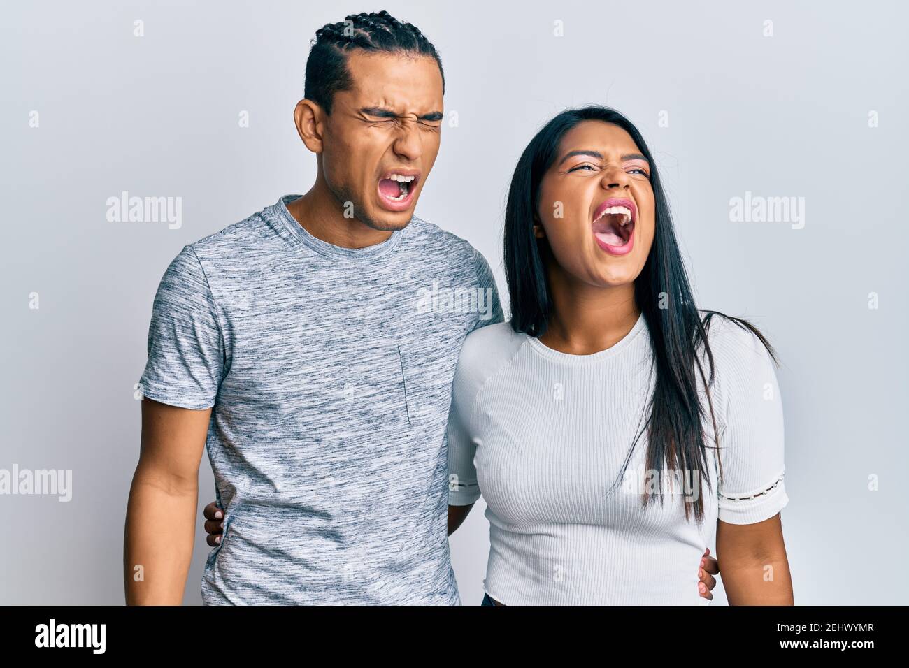 Young latin couple wearing casual clothes angry and mad screaming ...