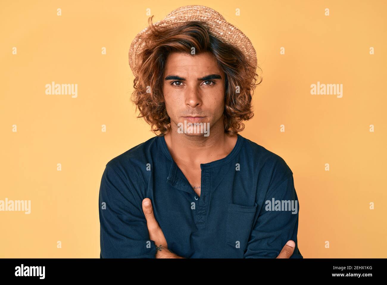 Young hispanic man wearing summer hat skeptic and nervous, disapproving ...