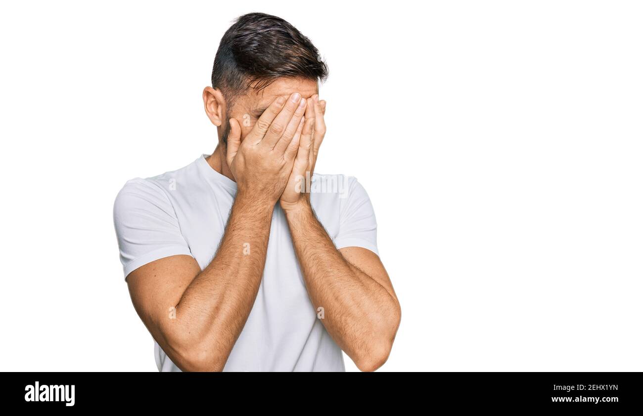 Handsome man with beard wearing casual white t shirt with sad ...
