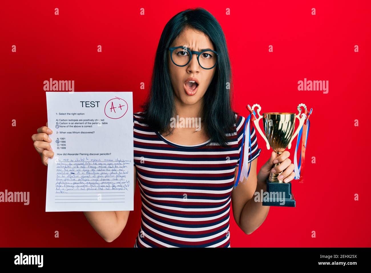 Beautiful asian young woman showing a passed exam holding trophy in ...