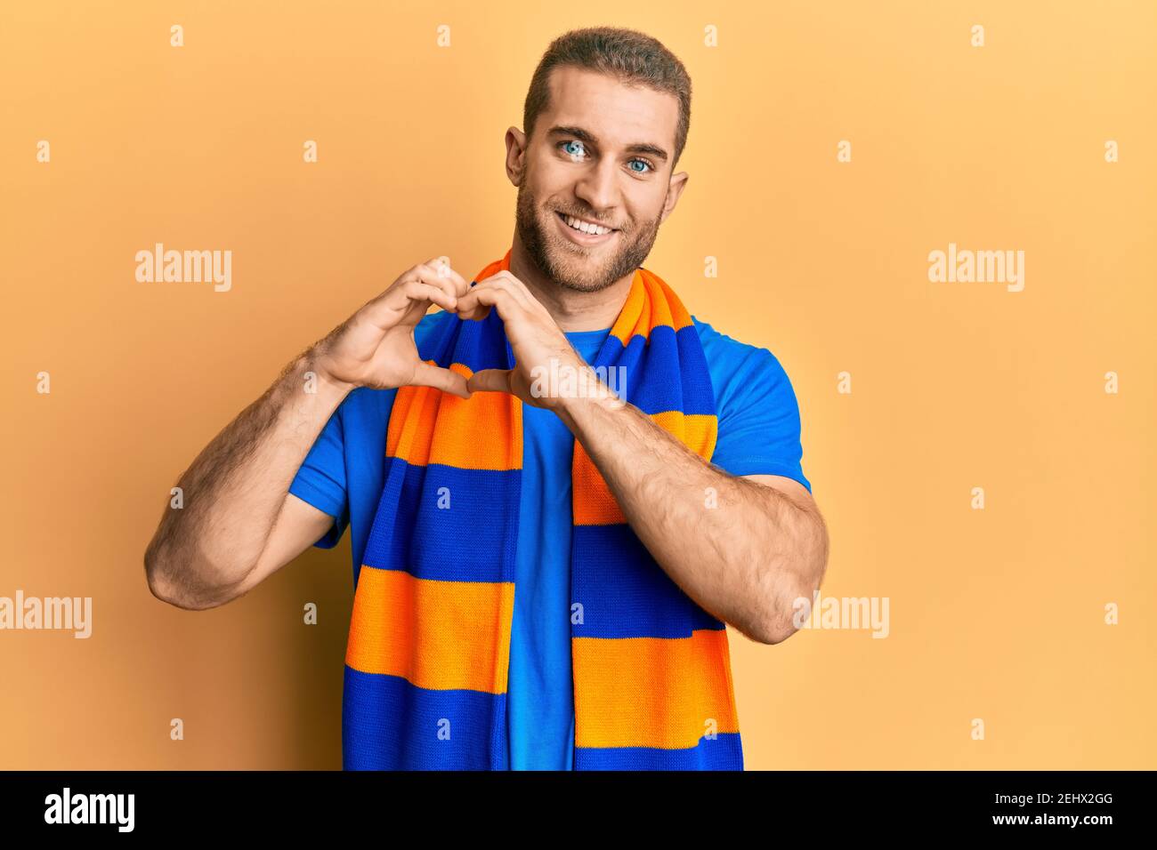 Young caucasian man football hooligan cheering game smiling in love ...