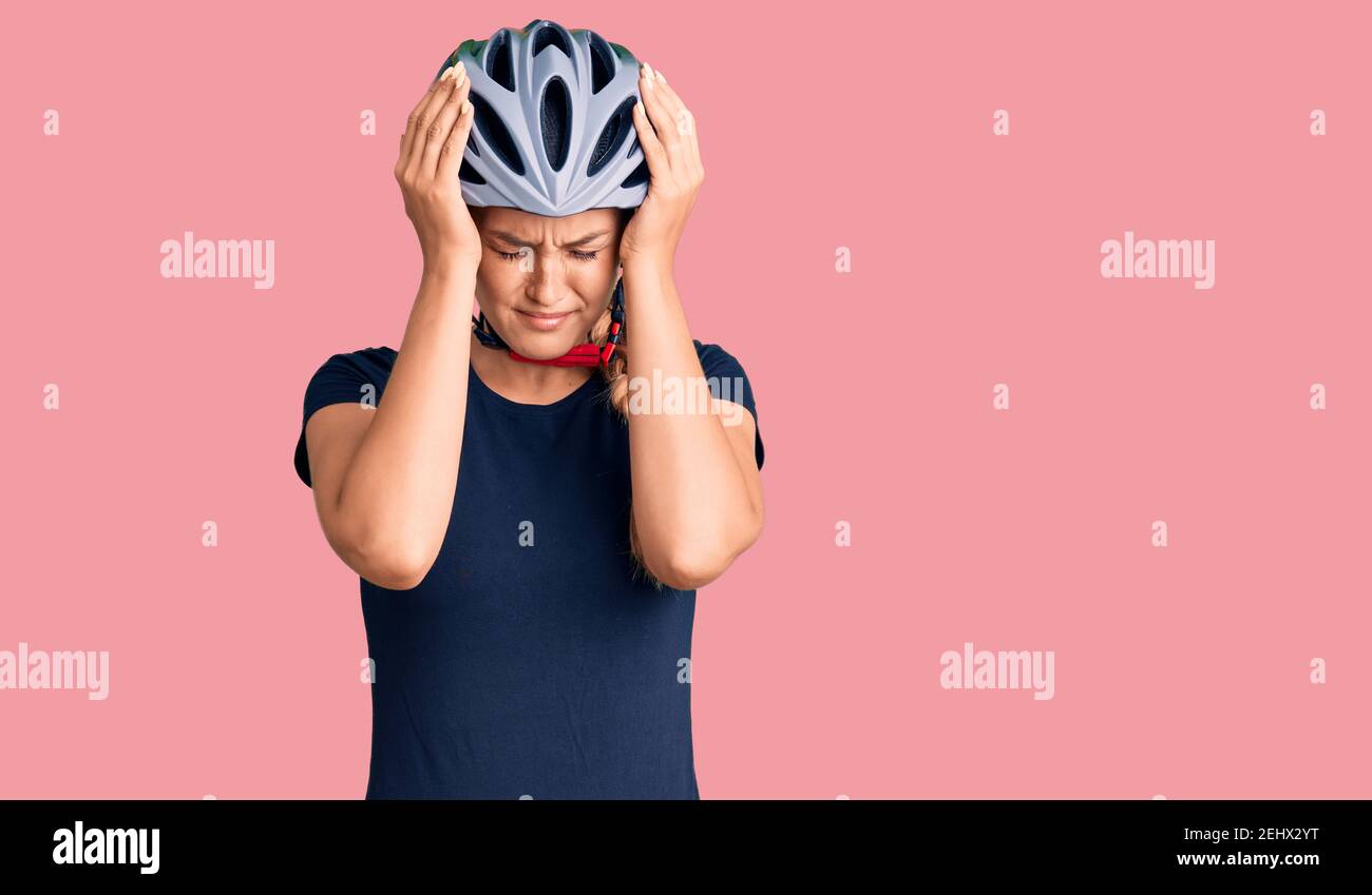 Beautiful caucasian woman wearing bike helmet suffering from headache ...