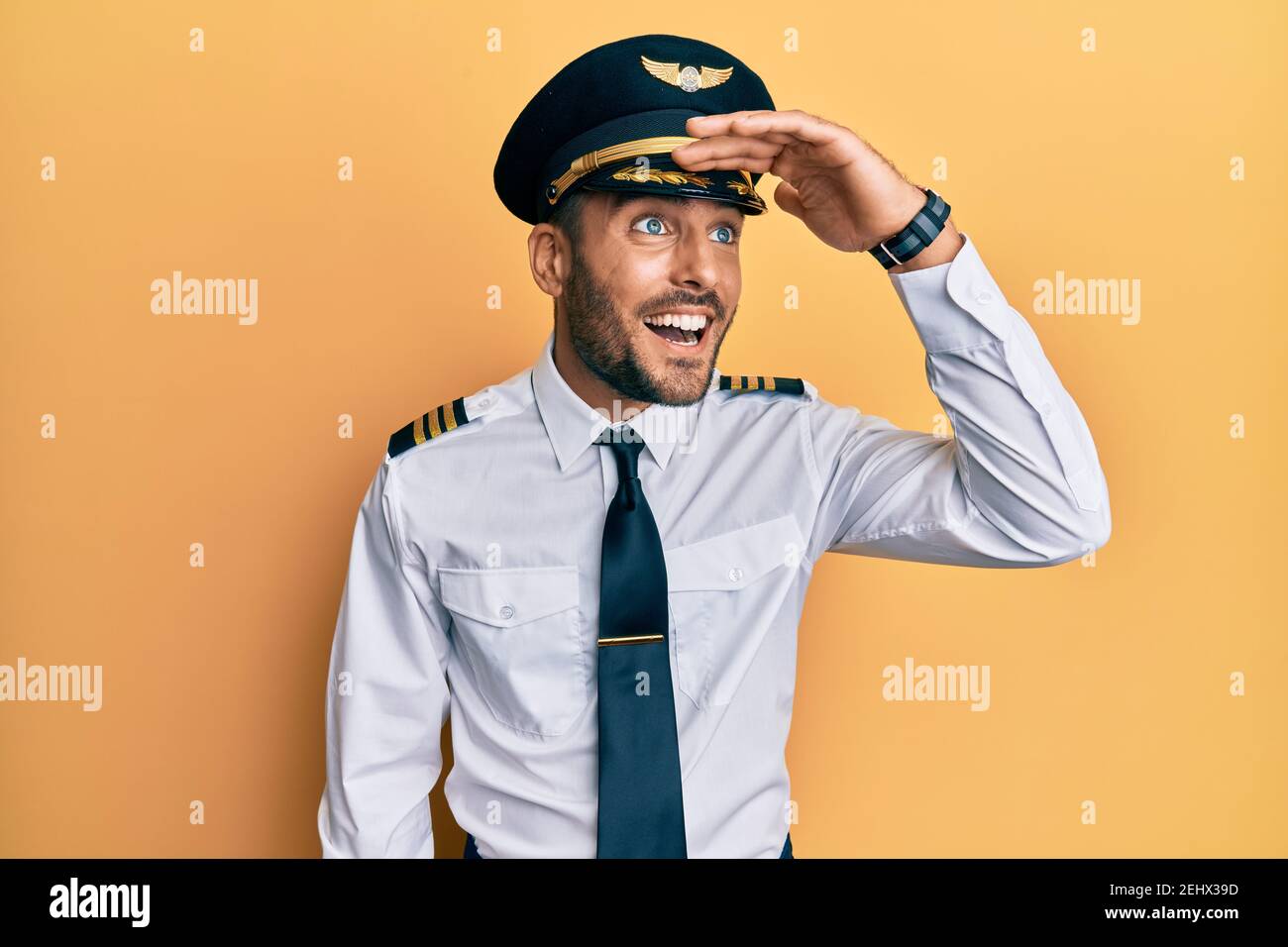 Handsome hispanic man wearing airplane pilot uniform very happy and ...