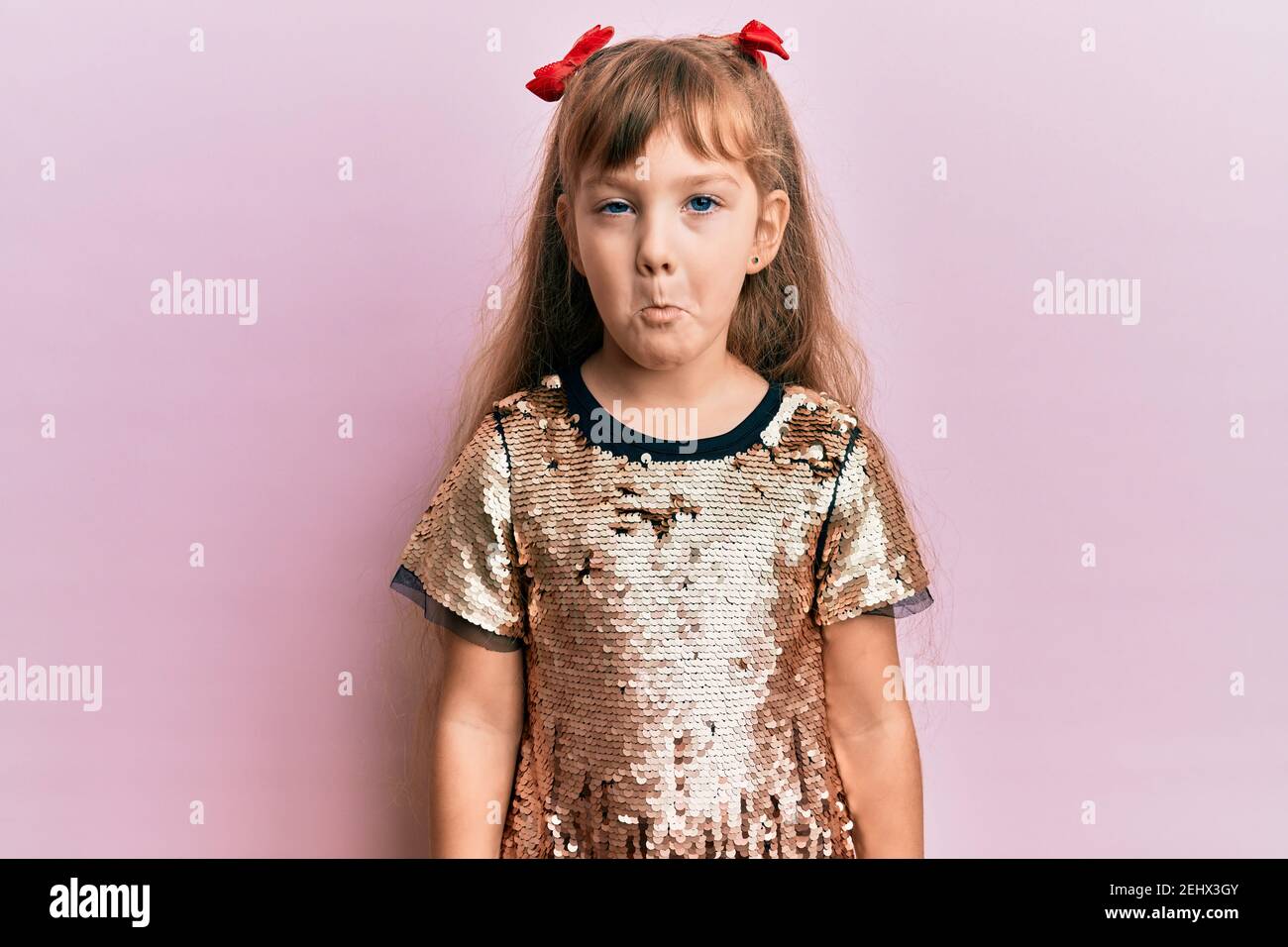 Little caucasian girl kid wearing festive sequins dress depressed and ...