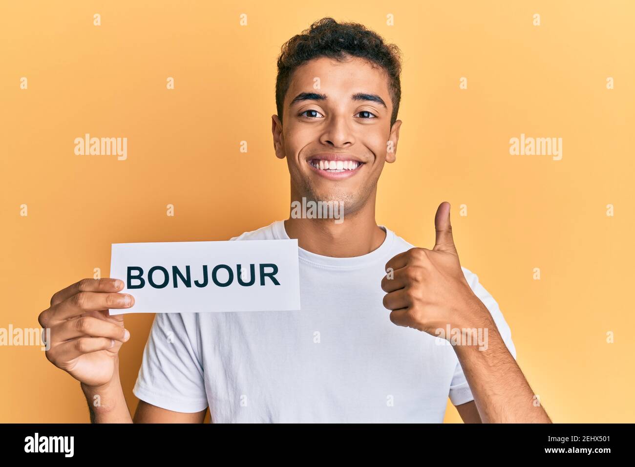 Young handsome african american man holding bonjour french greeting ...