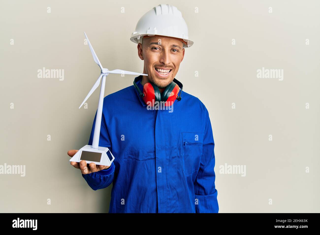 Bald engineer man with beard holding solar windmill for renewable ...
