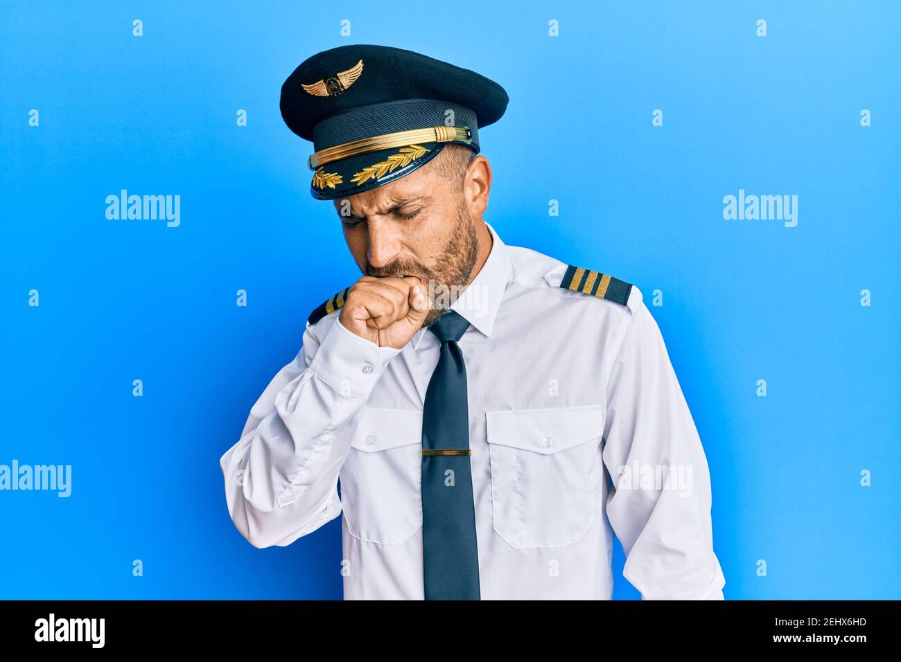 Handsome man with beard wearing airplane pilot uniform feeling unwell ...
