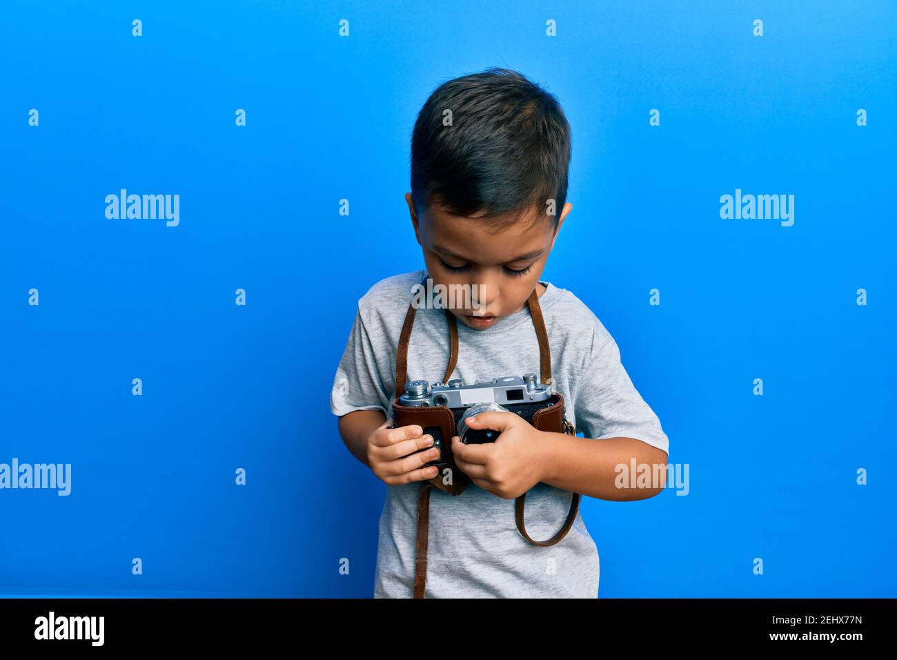 Adorable latin photographer toddler smiling happy using vintage camera ...