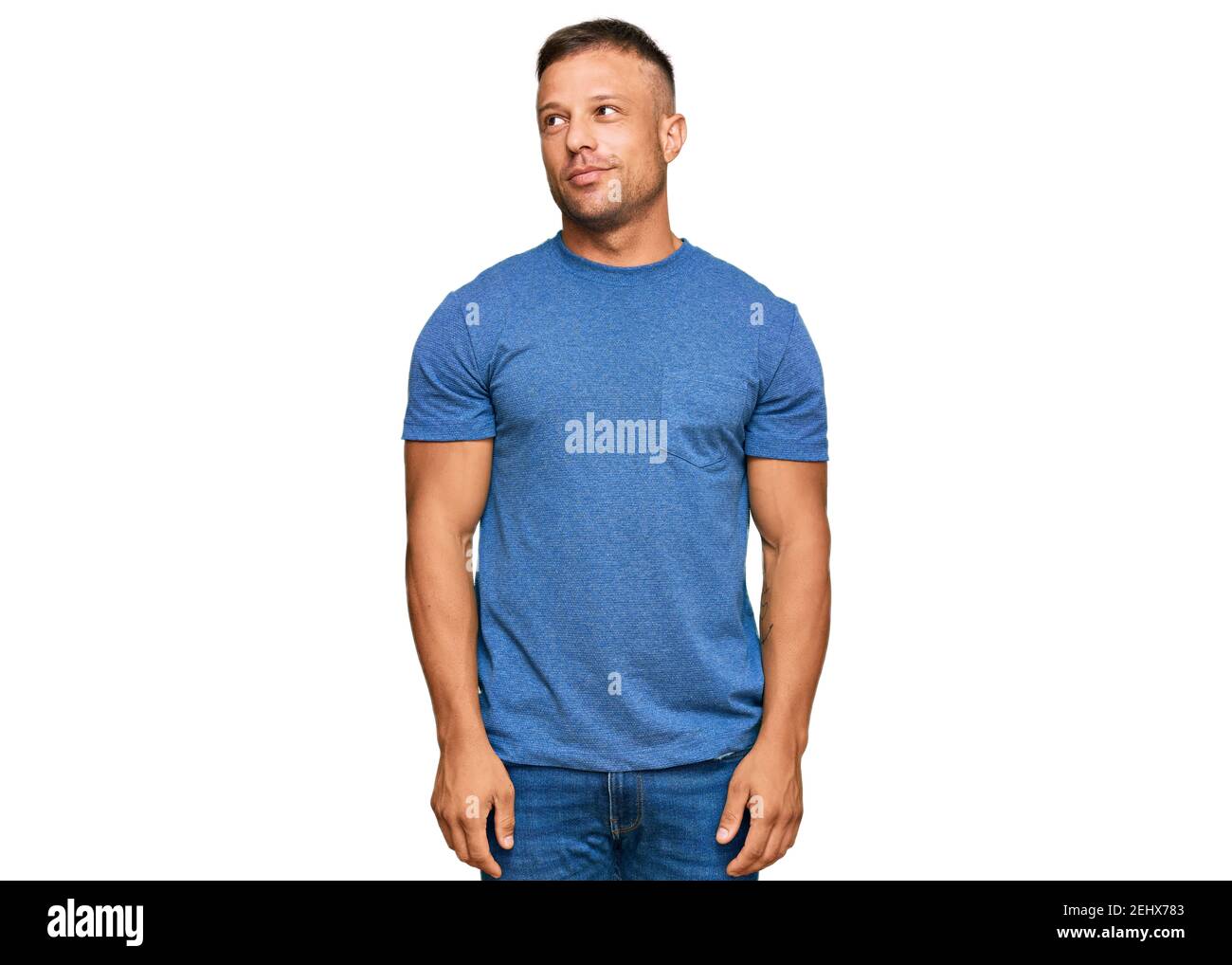 Handsome muscle man wearing casual clothes smiling looking to the side ...