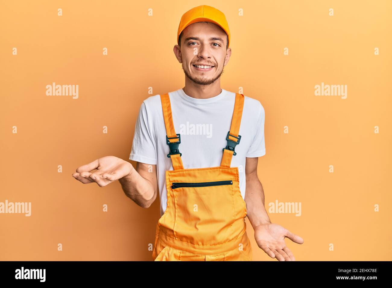 Hispanic young man wearing handyman uniform smiling cheerful with open ...