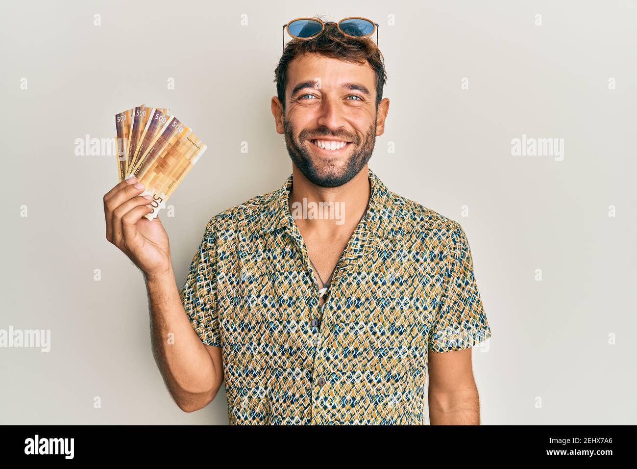 Handsome man with beard holding 500 norwegian krone banknotes looking ...