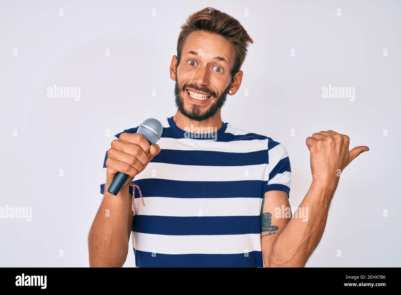 Handsome caucasian man with beard singing song using microphone ...