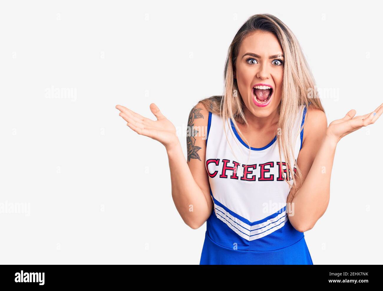 Young beautiful blonde woman wearing cheerleader uniform celebrating ...