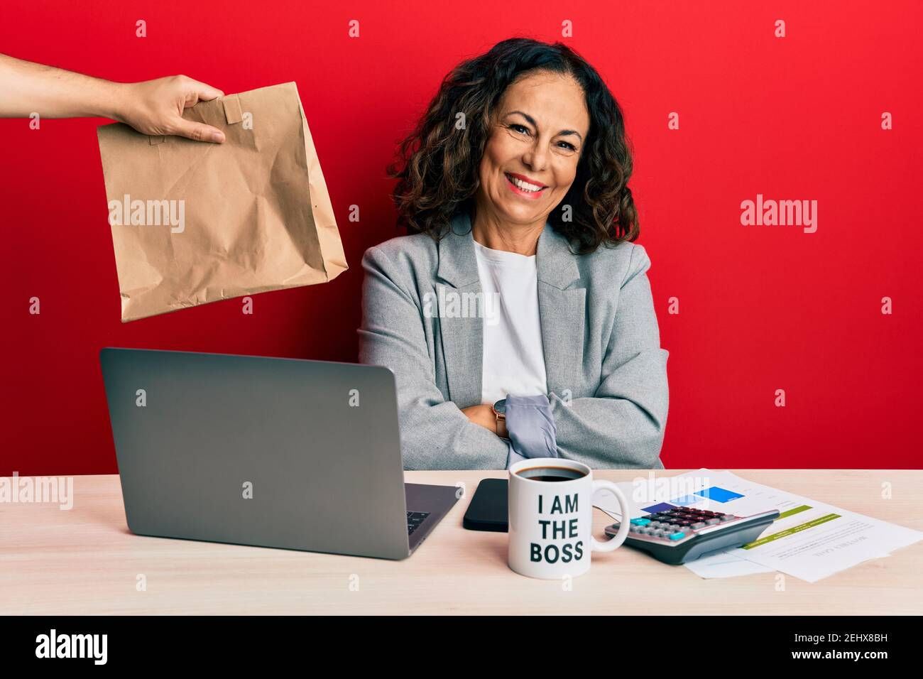 Beautiful middle age woman working at the office ordering delivery food ...