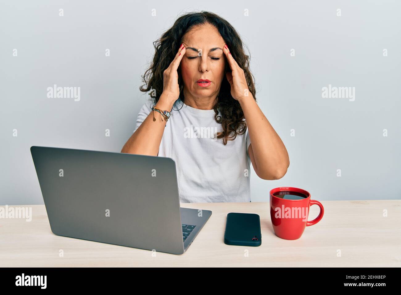 Beautiful middle age woman working at the office using computer laptop ...