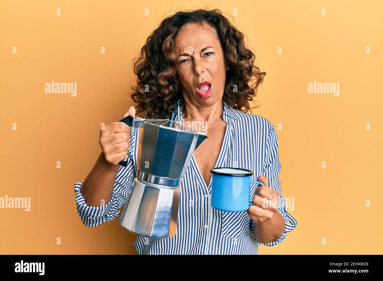 Middle age hispanic woman drinking italian coffee in shock face ...