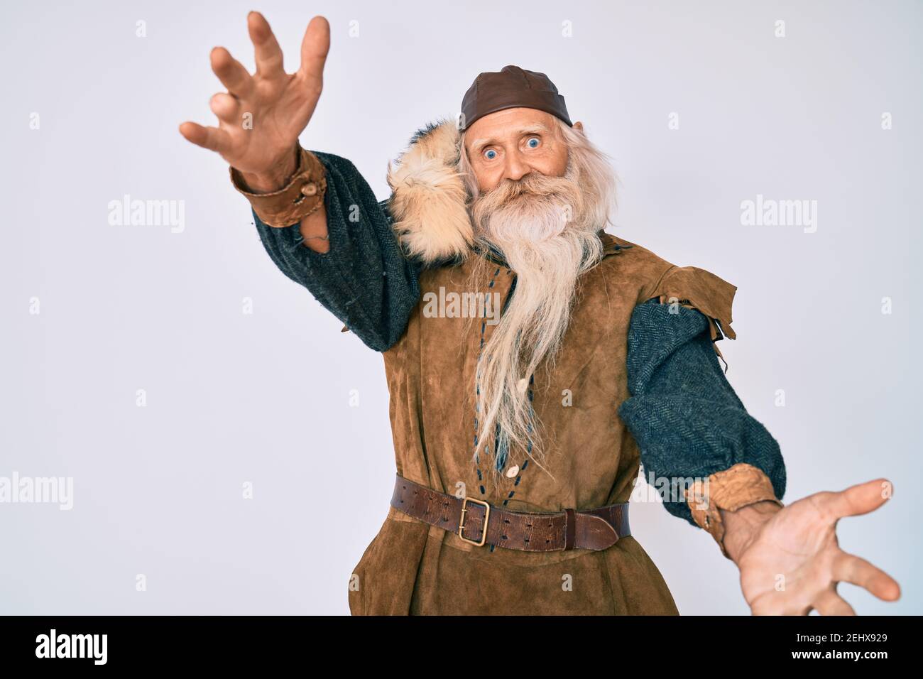 Old senior man with grey hair and long beard wearing viking traditional ...