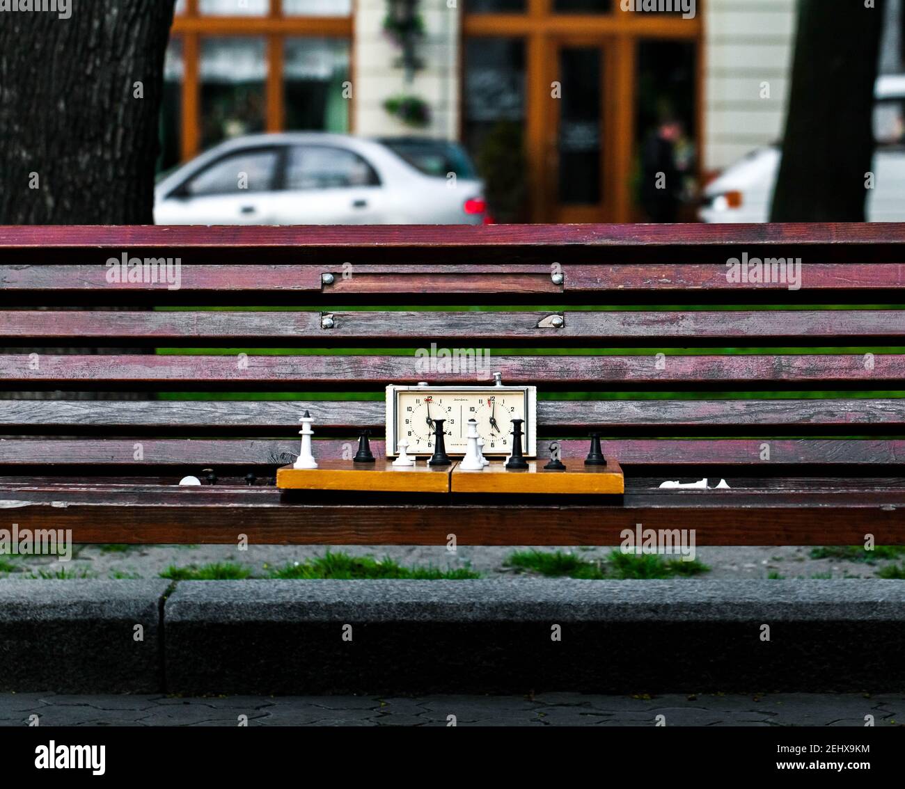 Chess board with chess pieces on wooden bench. Outdoors chess game with ...