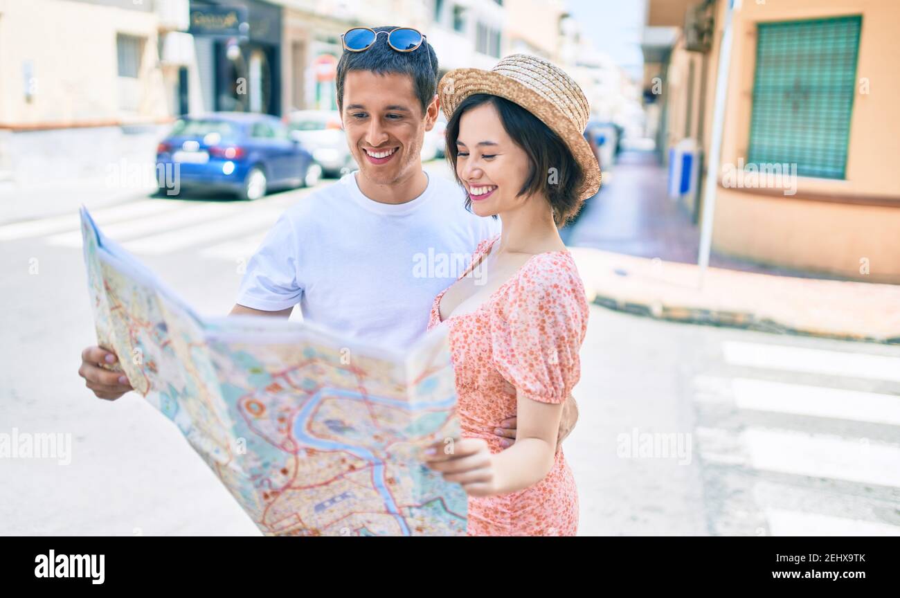 Beautiful couple on vacation smiling happy holding city map at street ...