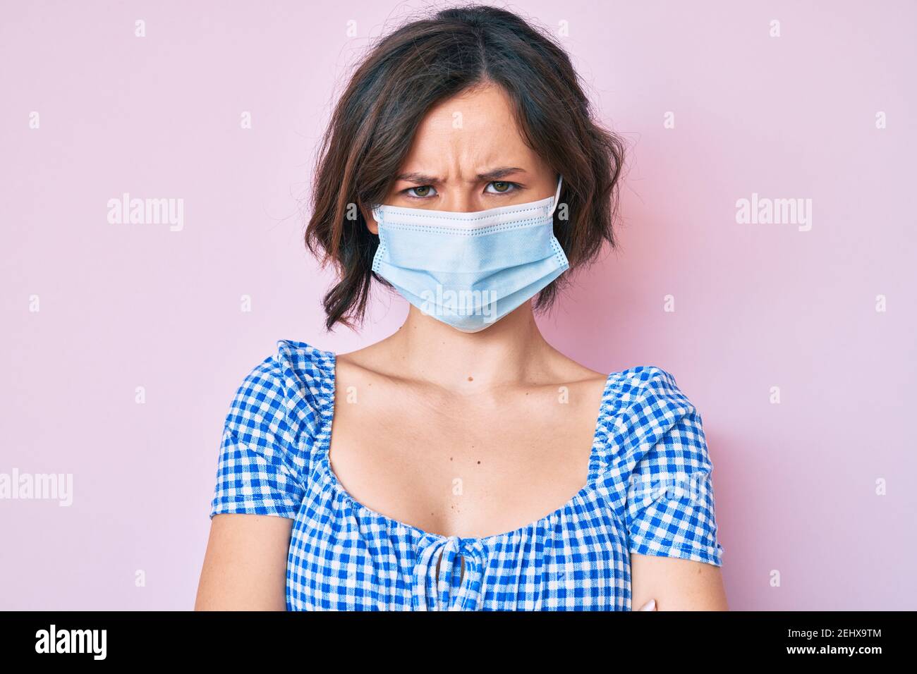 Young beautiful woman wearing medical mask skeptic and nervous ...