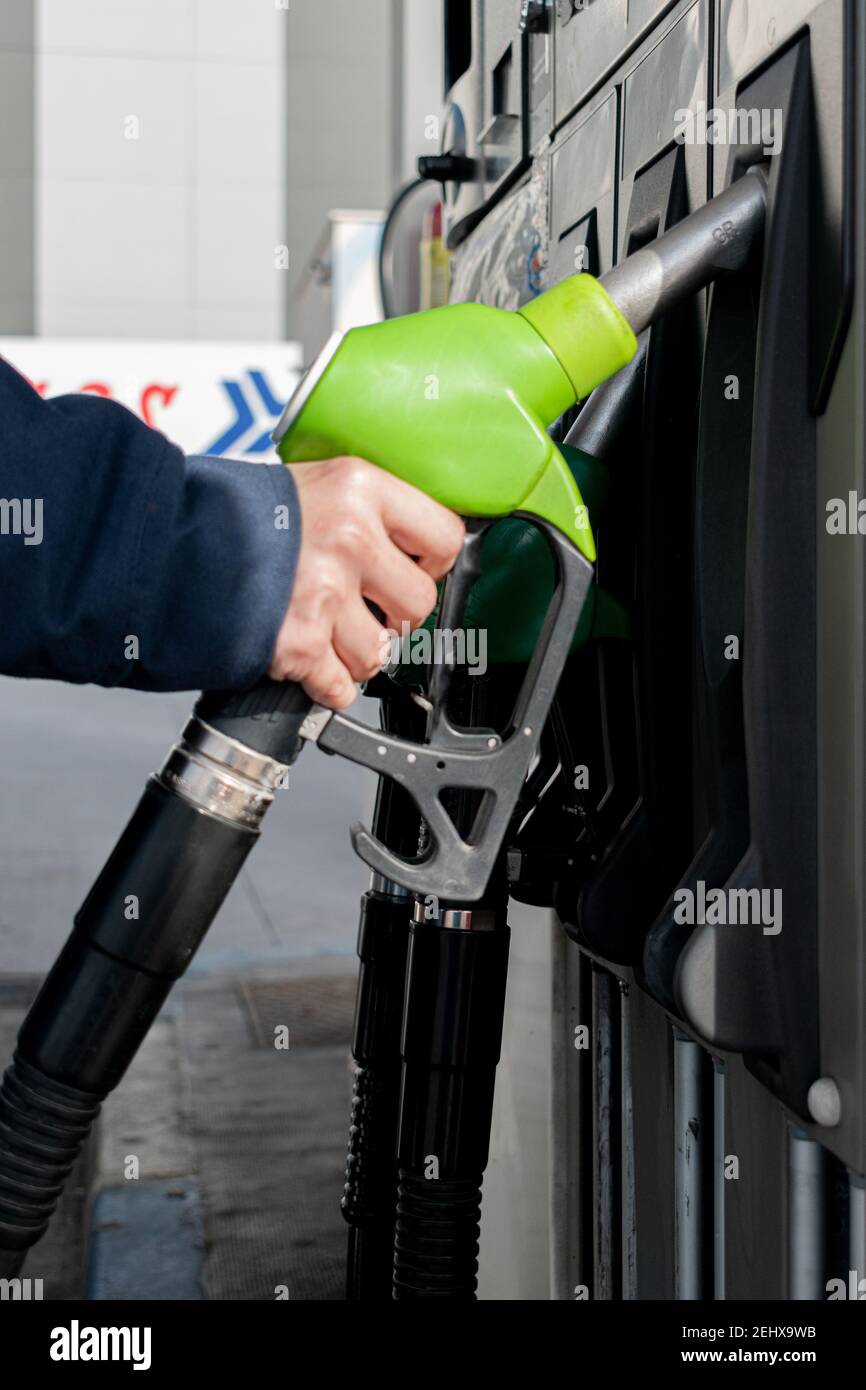 taking the hose from the gas pump to fill the tank of the vehicle Stock ...