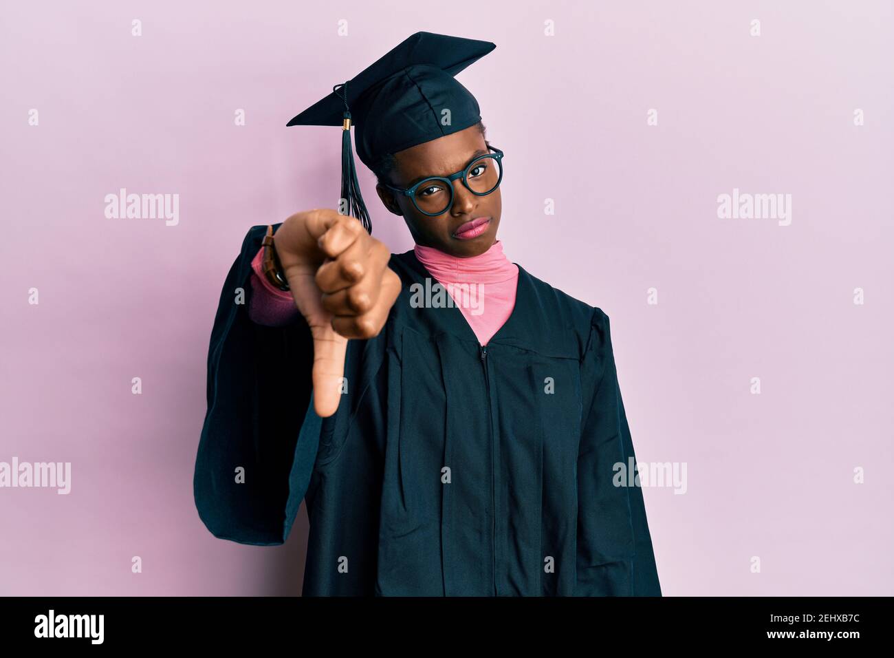Young african american girl wearing graduation cap and ceremony robe ...